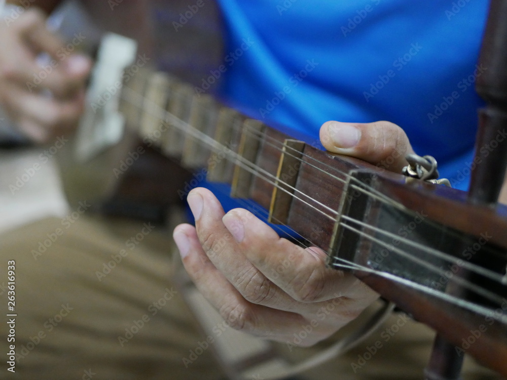 Hands of a musician playing Seung, plucked lute from the Lanna region ...