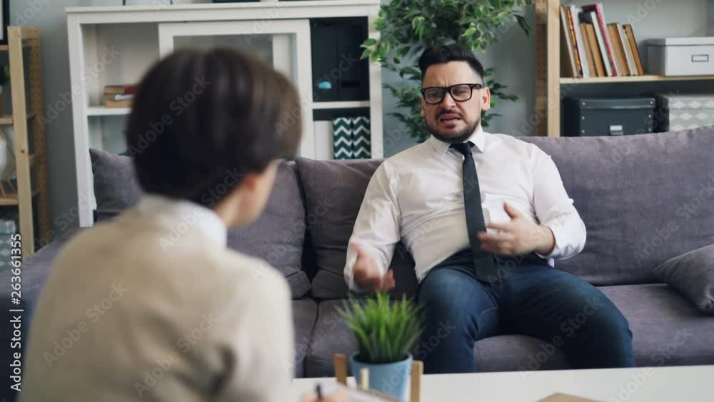 Angry CEO handsome emotional guy is talking to counselor expressing ...