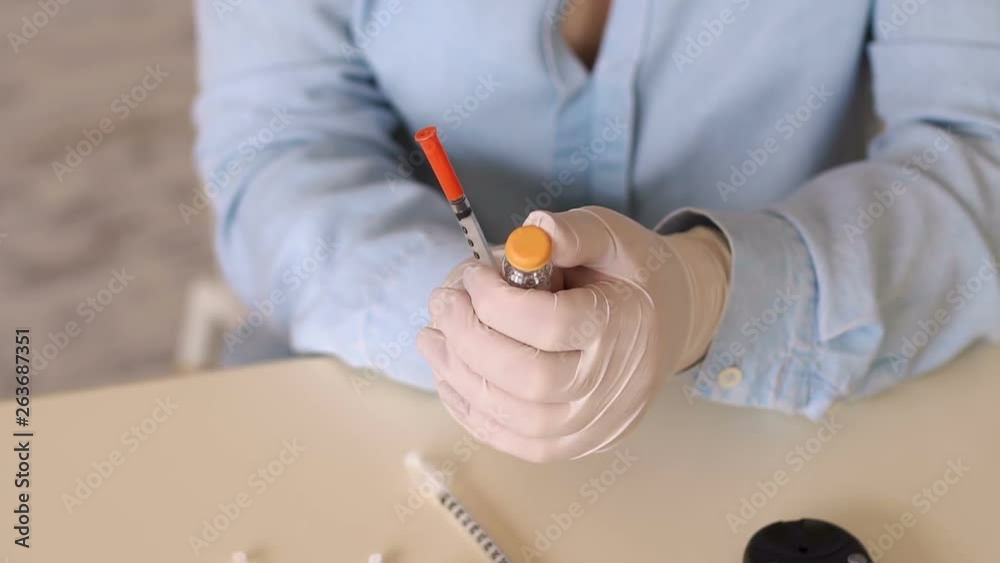 Close-up of a girl in medical gloves opens a sterile bottle of insulin ...
