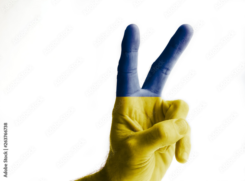 The hand of man painted in the colors of the Ukrainian flag shows a ...