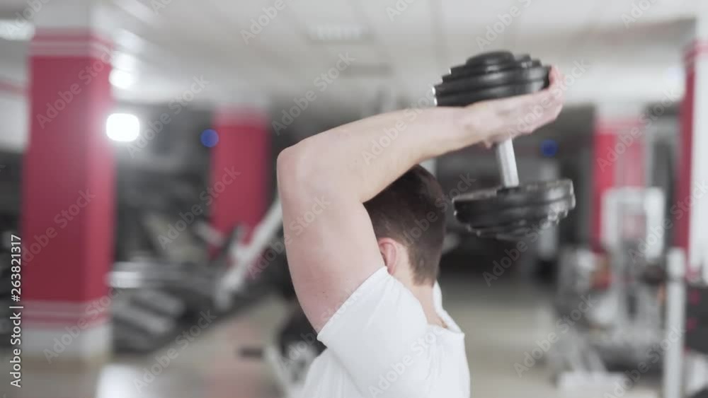 Close Up Footage of Young Male in White Shirt in Gym Lifting Weights ...