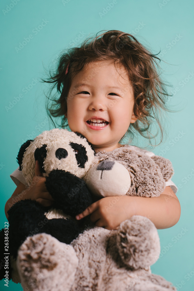 Little kid hugging stuffed animals Stock Photo | Adobe Stock