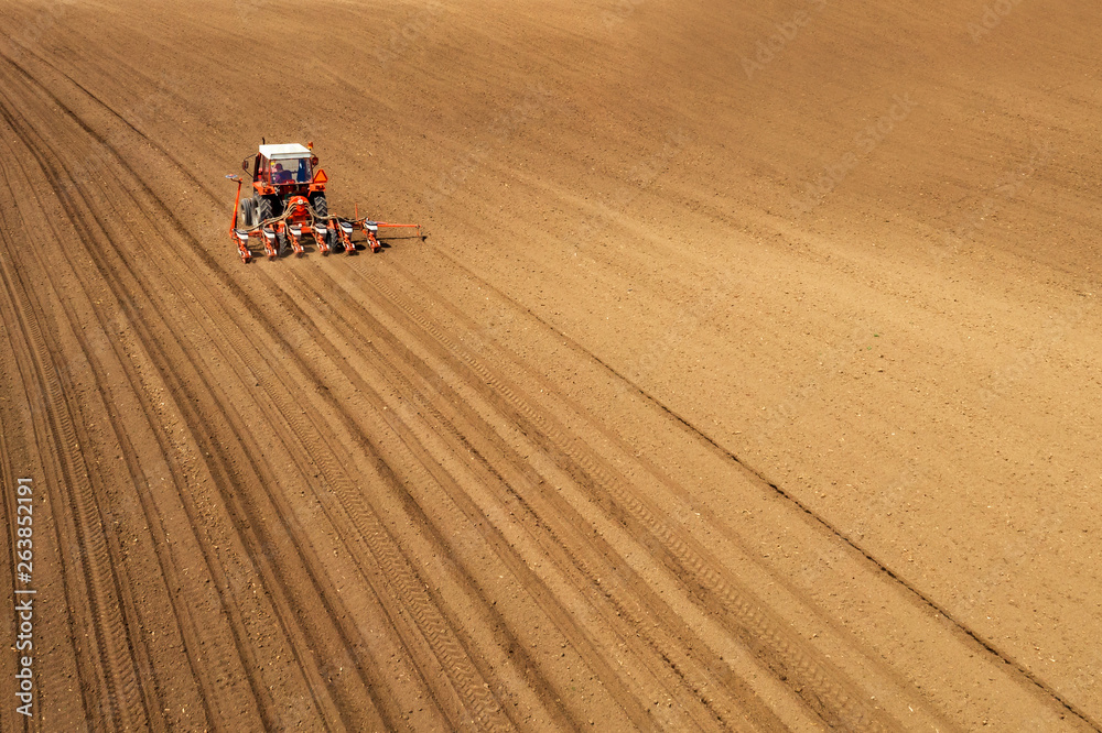 Aerial view of tractor sowing and planting corn in field Stock Photo ...