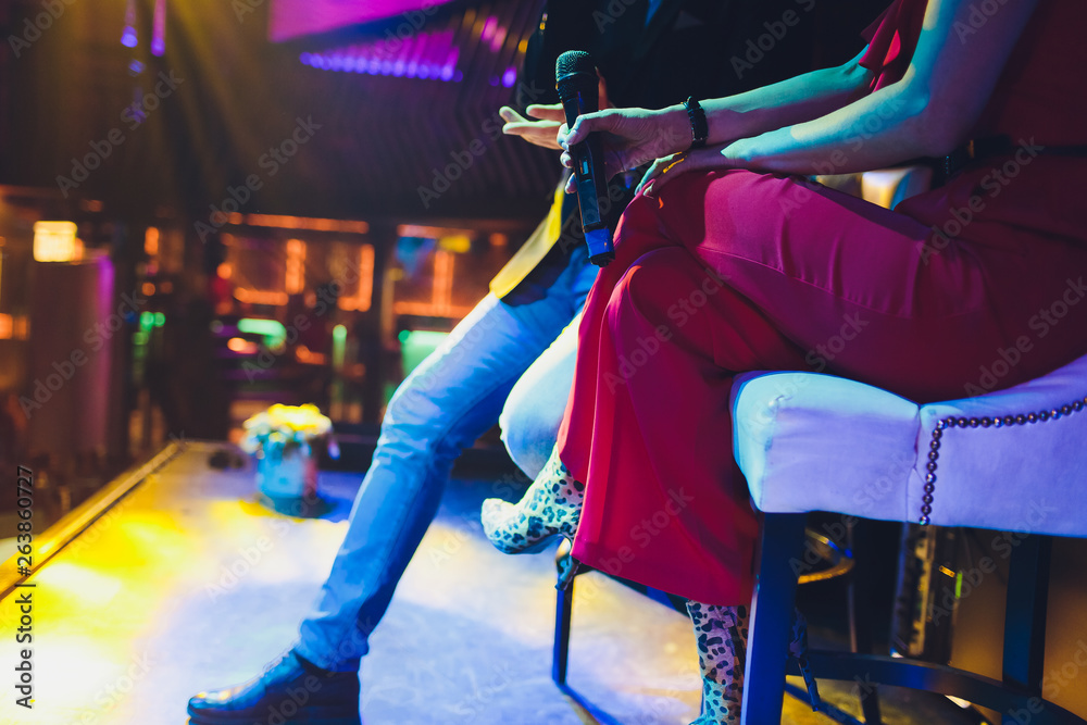 The female student is holding the black wireless microphone in the left ...