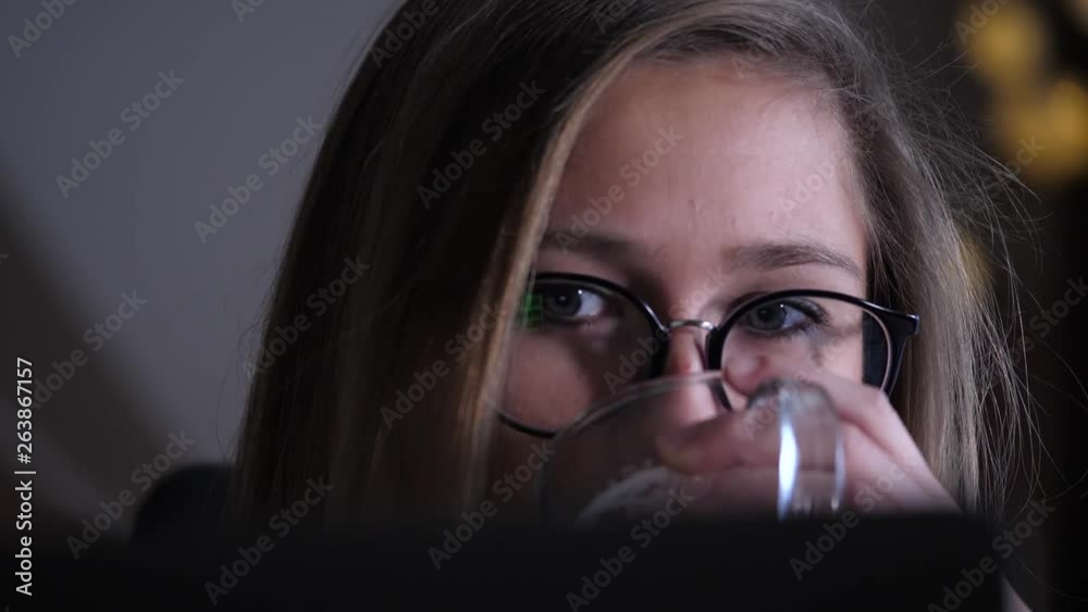 Vidéo Stock Face of a young woman behind computer's screen. She is ...