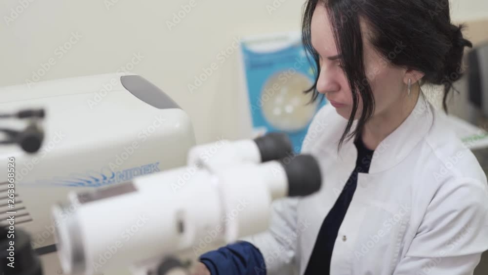 A young beautiful female brunette doctor/eye specialist/ophthalmologist ...