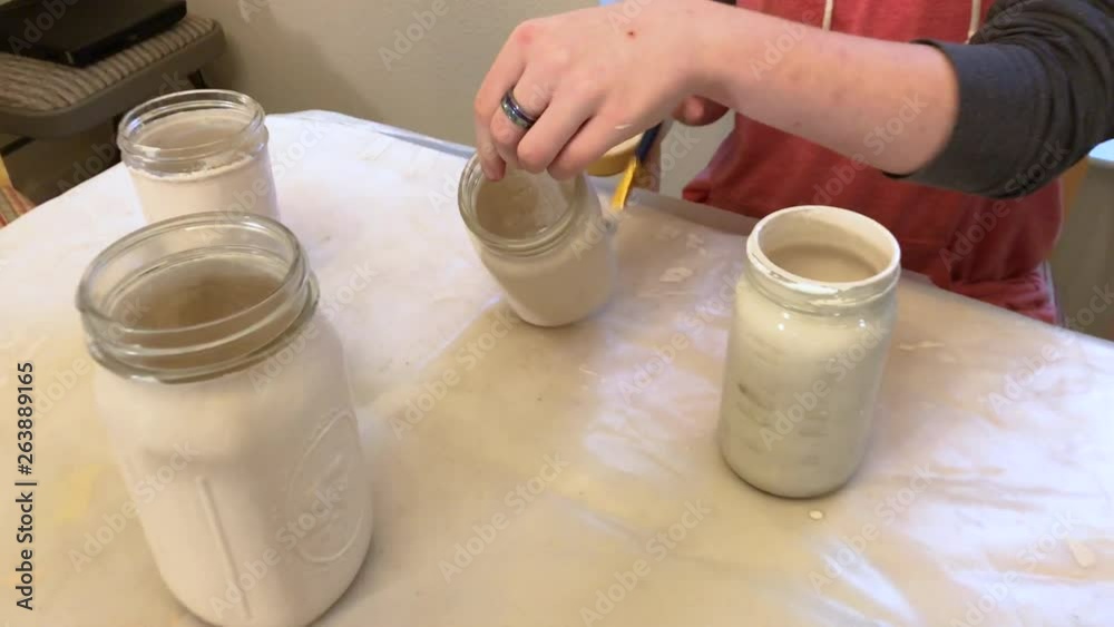 Camera zooming in on a person recycling and upcycling mason jars by ...