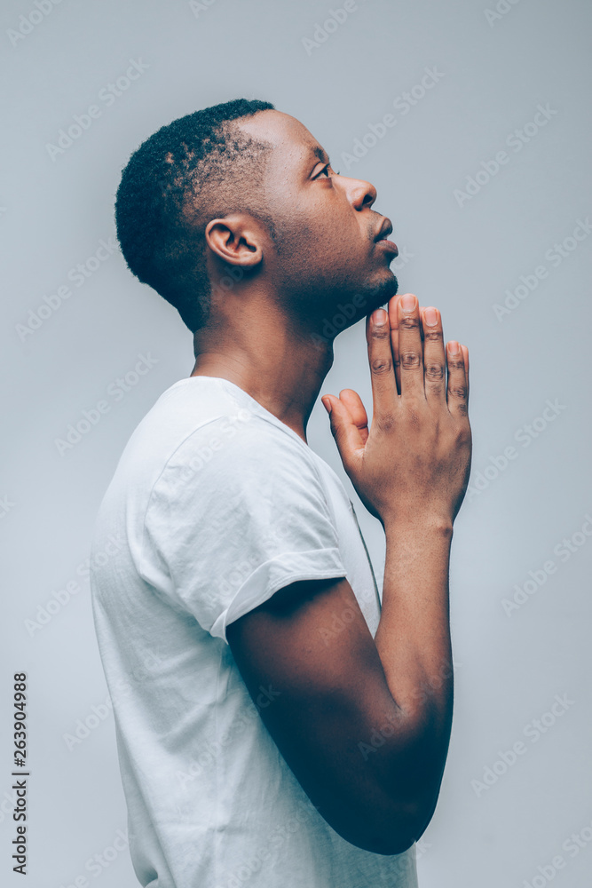 Religion and faith. Side view of afroamerican guy praying God, hoping ...