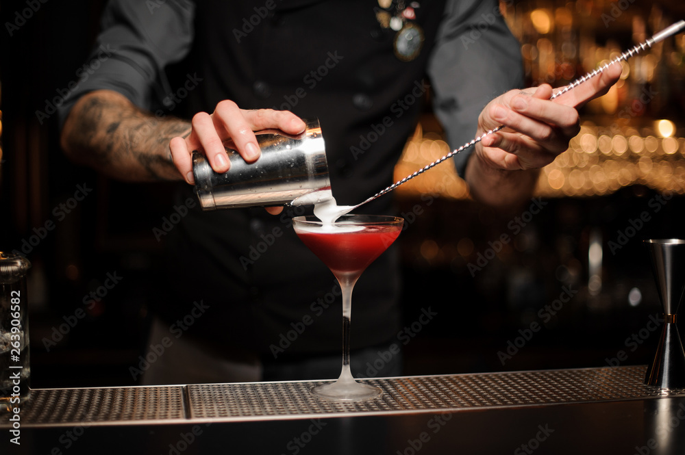 Bartender pouring cocktail using shaker and spoon Stock Photo | Adobe Stock