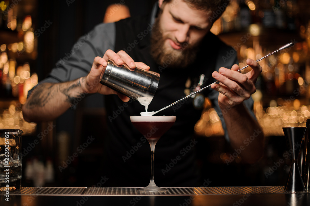 Male bartender makes cocktail using shaker and spoon Stock Photo ...