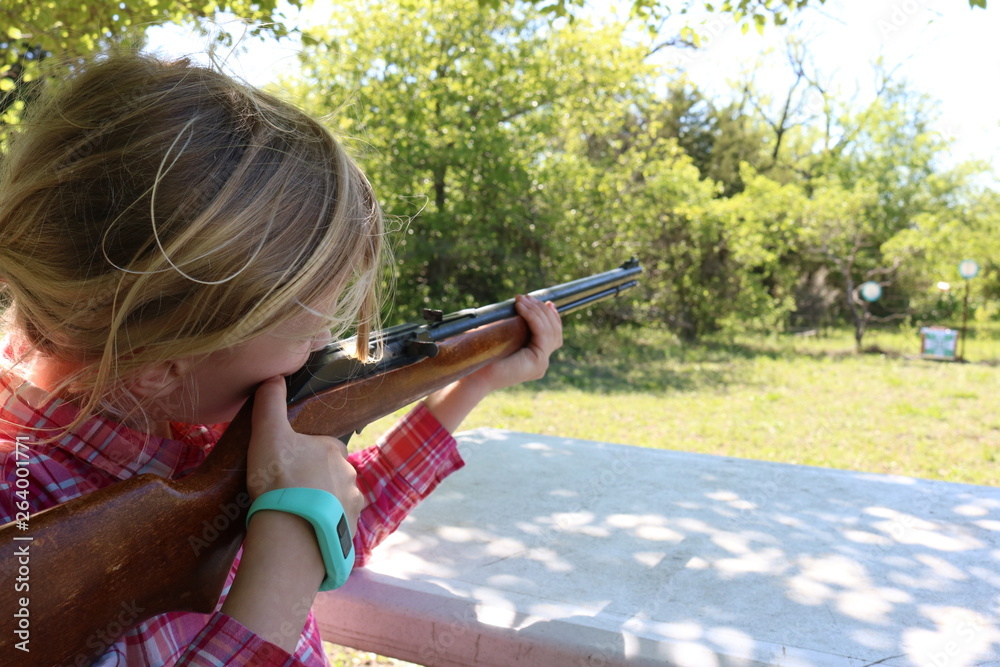 Girl aiming to shoot at target Stock Photo | Adobe Stock