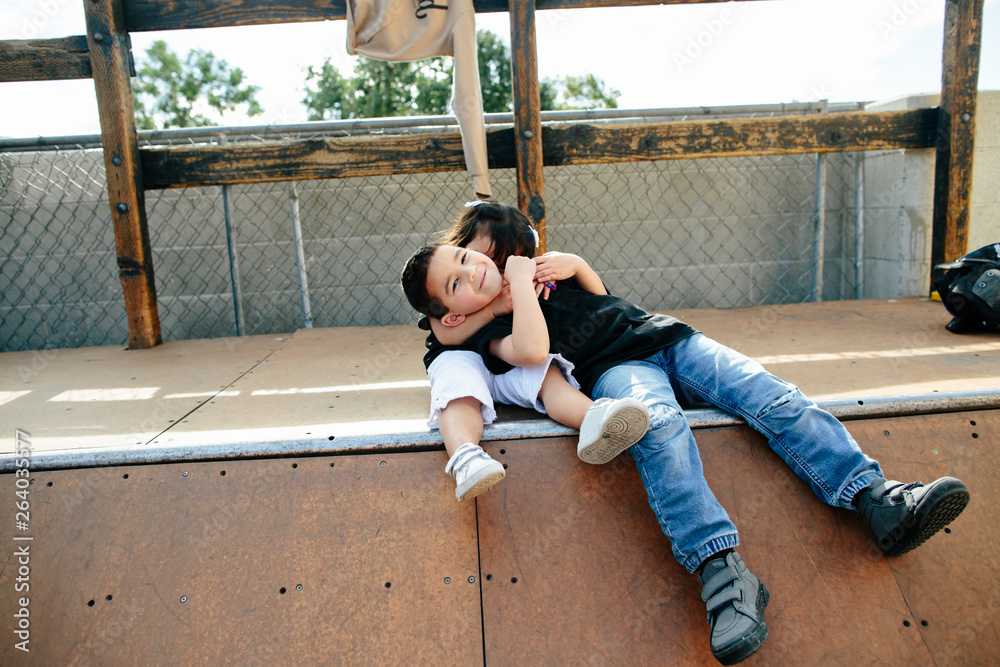Little girl strangle holds brother on half pipe Stock Photo | Adobe Stock