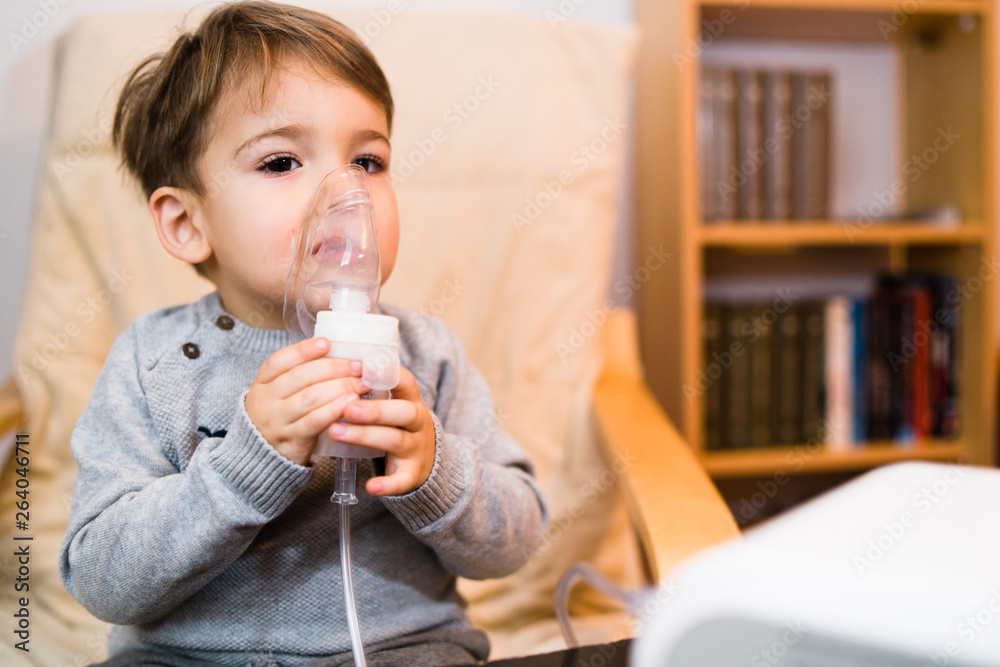 Little boy using steam inhaler nebulizer mask inhalation at home ...