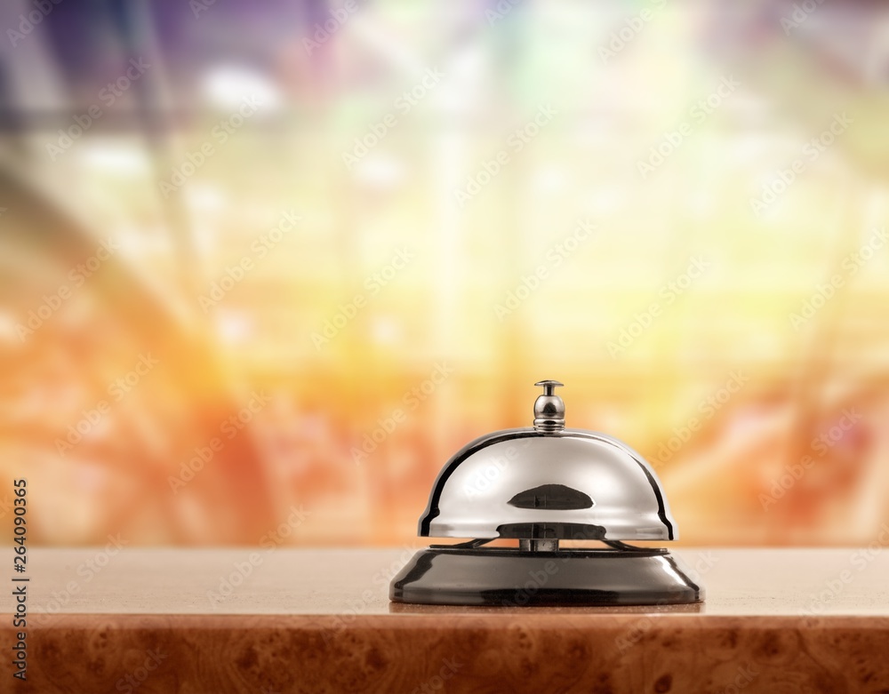 Vintage hotel reception service desk bell on blurred background, bokeh ...