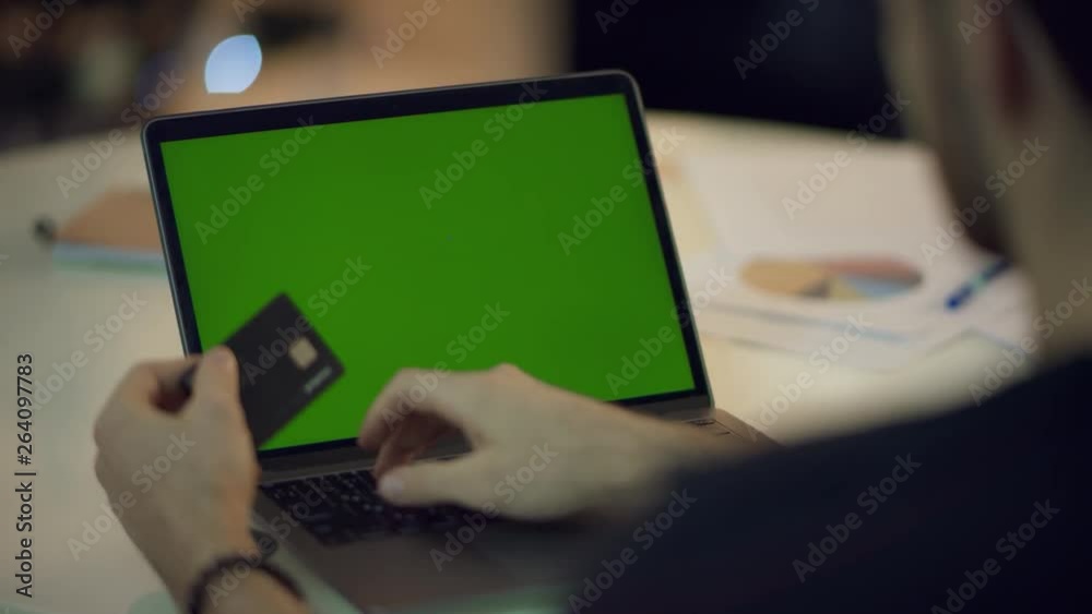 Male hands typing credit card number at laptop computer green screen ...