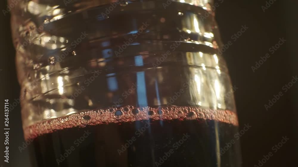 dark red liquid shaken in a transparent plastic container.close-up ...