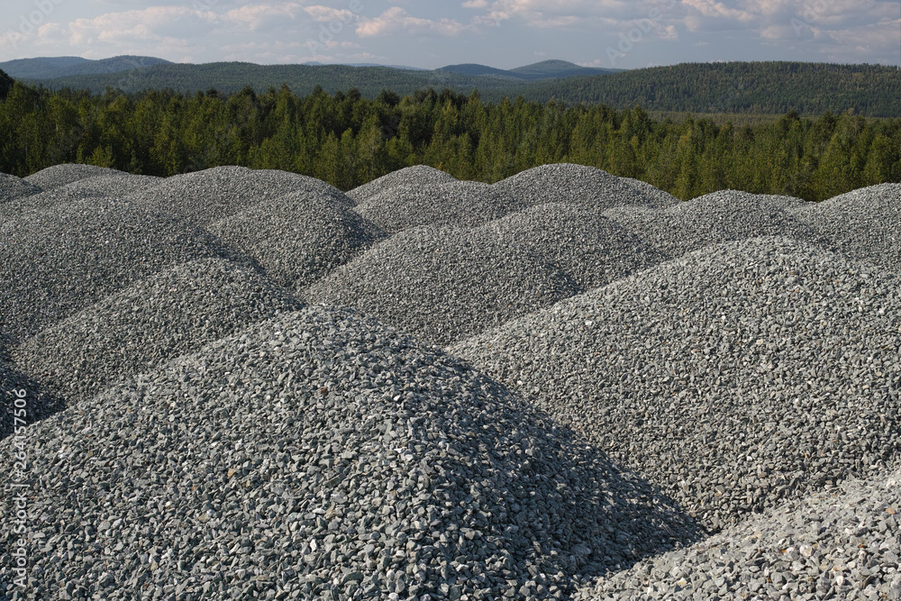Foto de Gravel folded into large piles stored in the open air. High ...