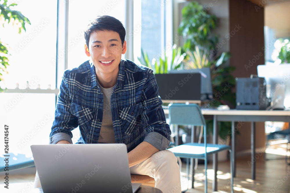Young college student using laptop in classroom Stock Photo | Adobe Stock