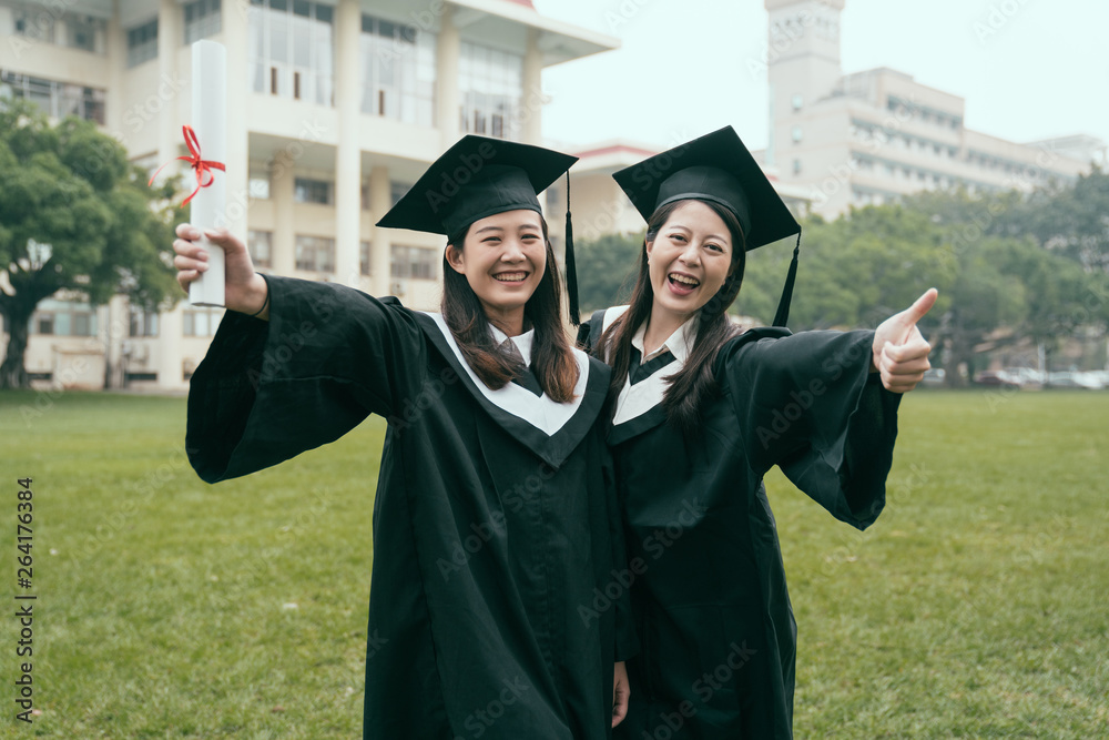 authentic lifestyle concept. two young asian college girls friends student smiling on graduation ...