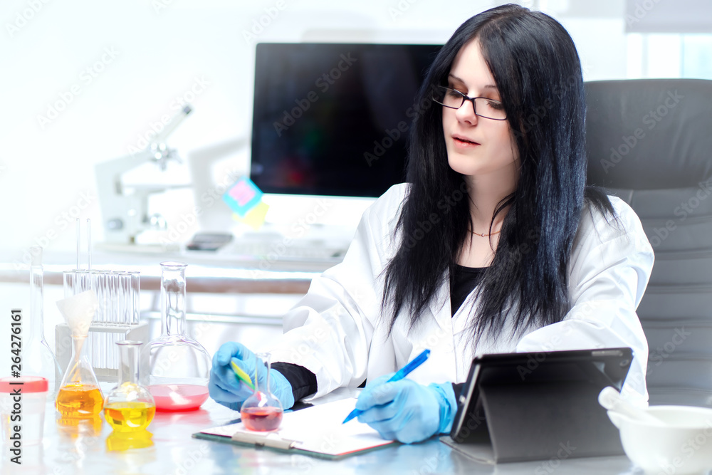 Chemical laboratory. Female laboratory assistant records the results of ...
