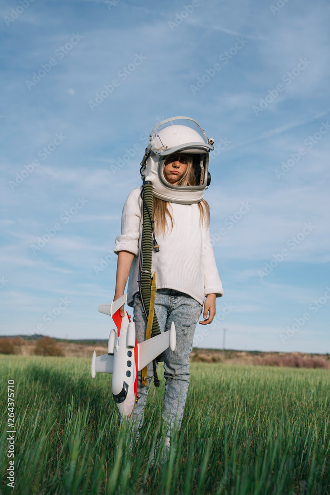Adorable little girl wearing a helmet and playing alone with a space ...