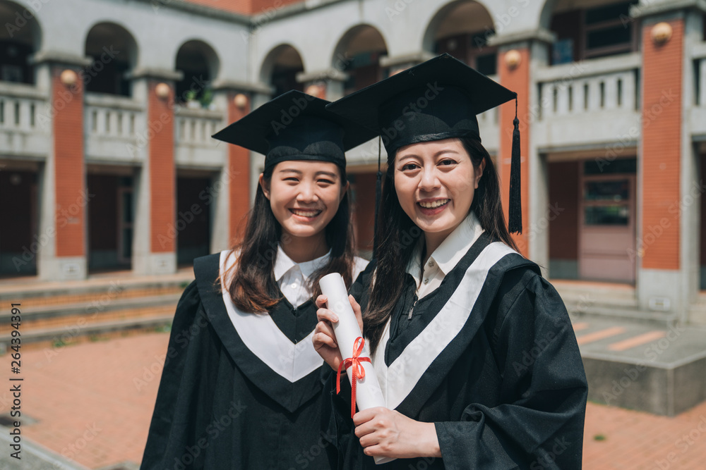 Young asian women wearing graduate uniform standing outdoor with red ...
