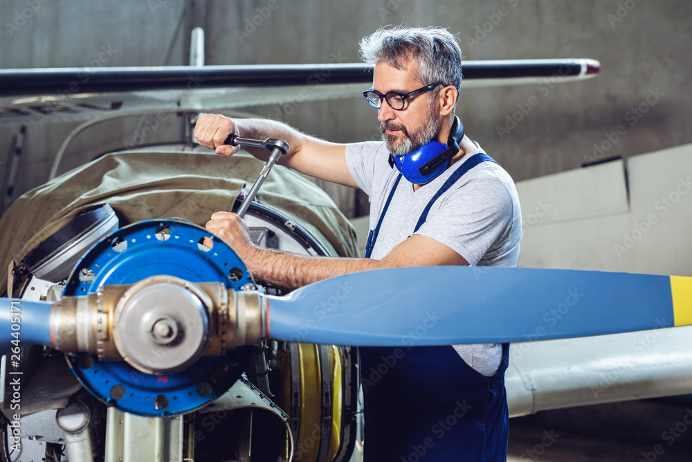 Aircraft mechanic repairs an aircraft engine Stock Photo | Adobe Stock