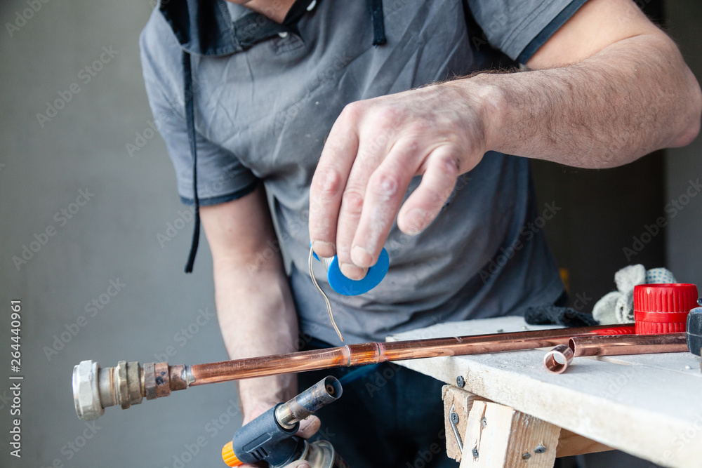 Closeup professional master plumber holding flux paste for soldering ...