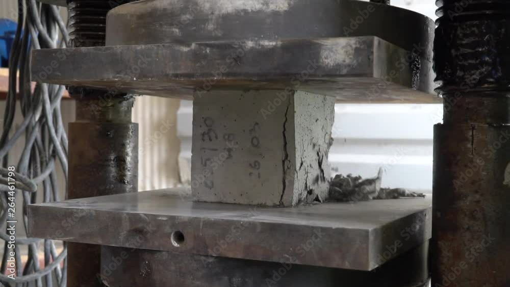 Concrete block breaks under high pressure. Hydraulic press is creating ...