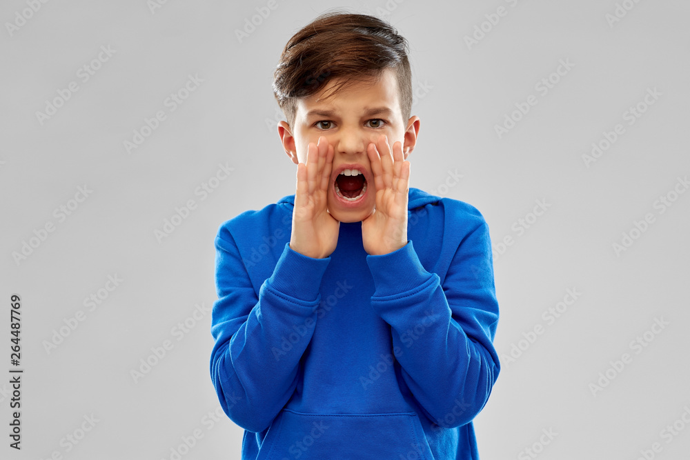 childhood, expressions and bullying concept - angry boy in blue hoodie ...