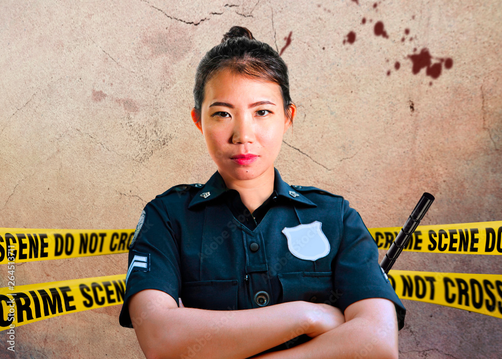 young Asian American police officer standing serious in custody of ...