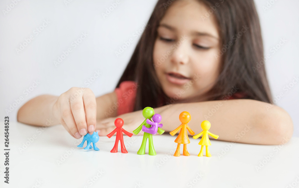 Happy traditional family figurines. A small child plays with colored ...
