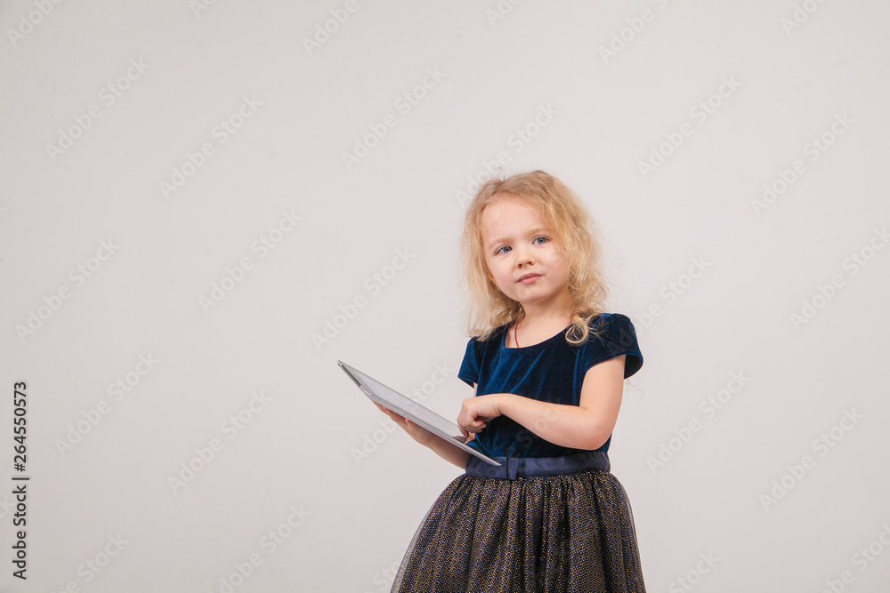The little girl using the tablet on the white wall background Stock ...