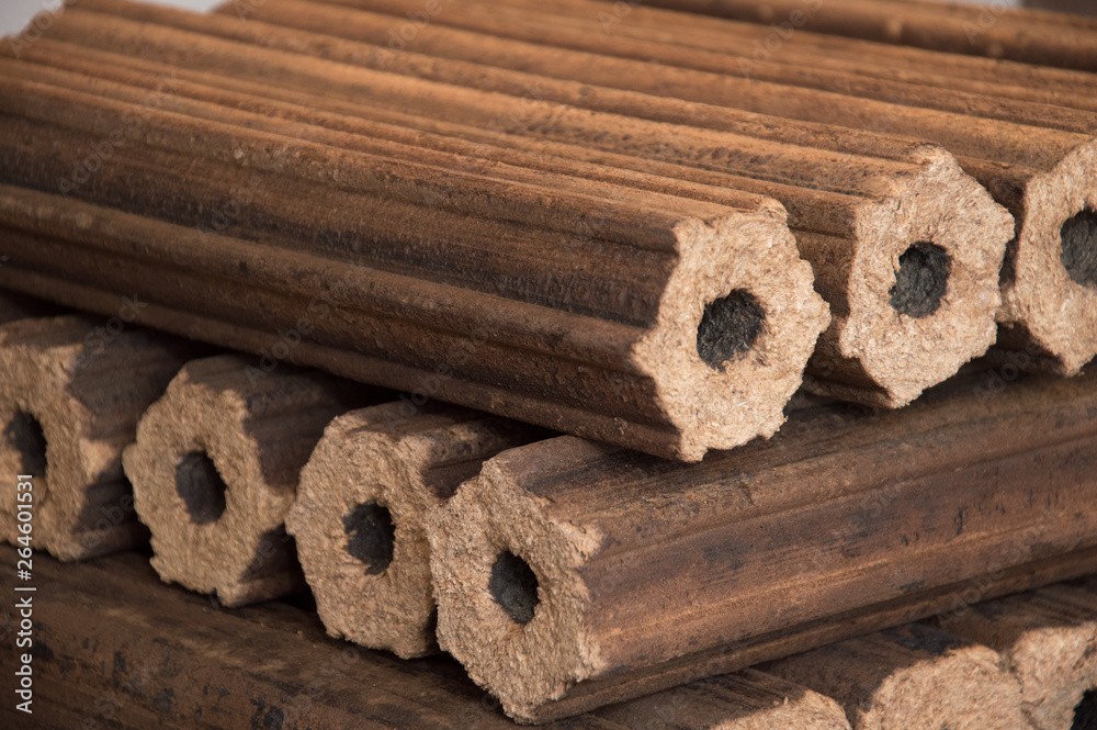 Fuel briquettes folded in rows on a white background. Wooden briquettes ...
