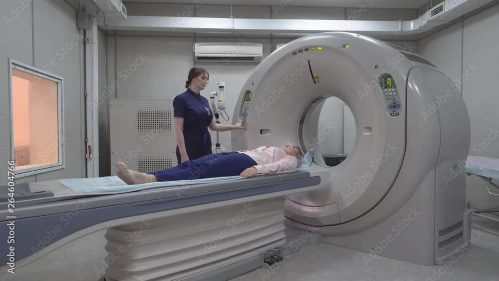 A scanning room with computers and monitors next to the CT scan room in ...