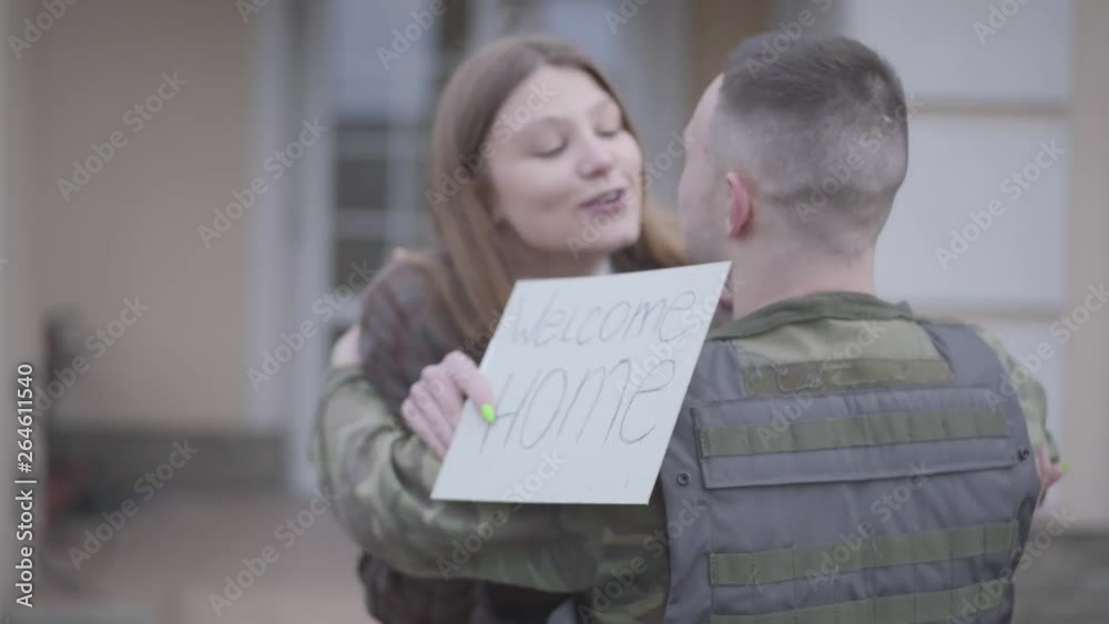 The young soldier in military closes with big bag cuddling with his ...