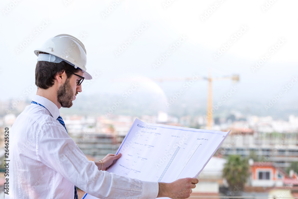 Foto de Giovane ingegnere con camicia bianca, cravatta blu e caschetto ...