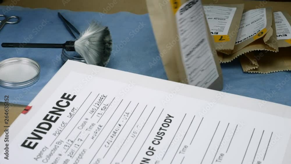 Scientific police officer examining evidence bags labeled in ballistic ...
