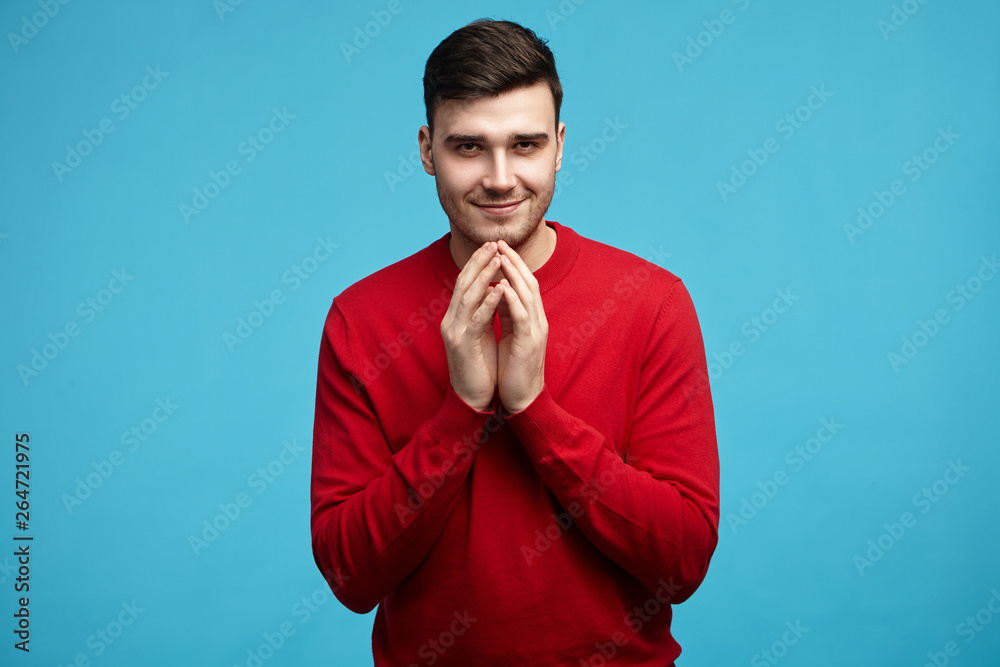 Cunning tricky young dark haired man clasping his hands, having ...