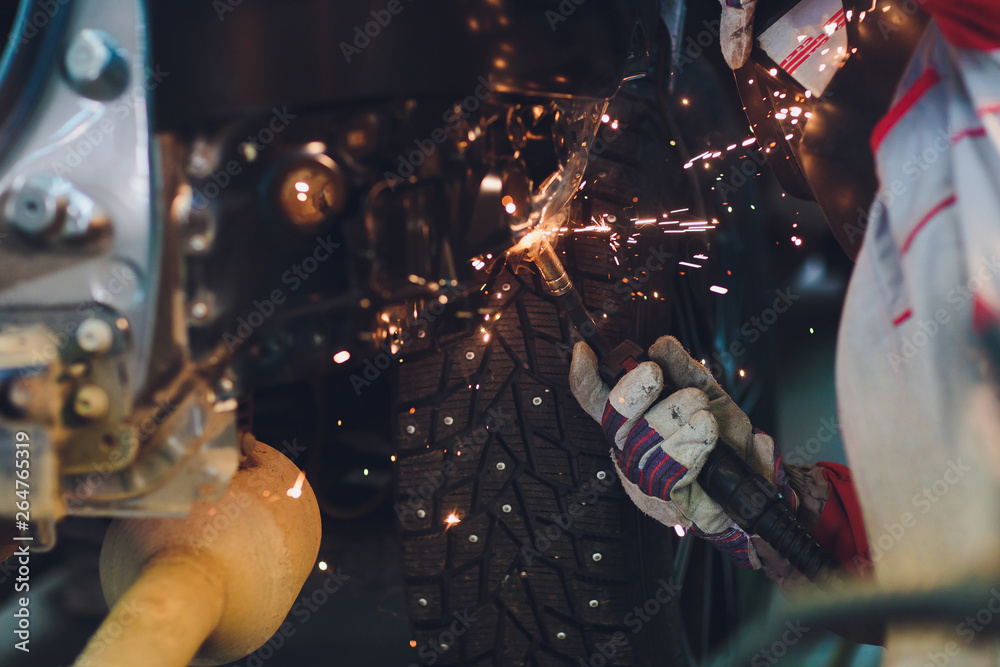 professional repairman worker in automotive industry welding metal body ...