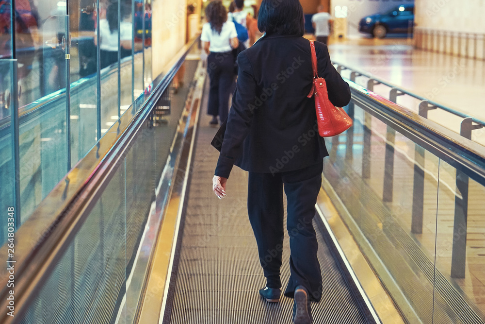 Women at horizontal escalator covered. Moving walkway, moving sidewalk ...
