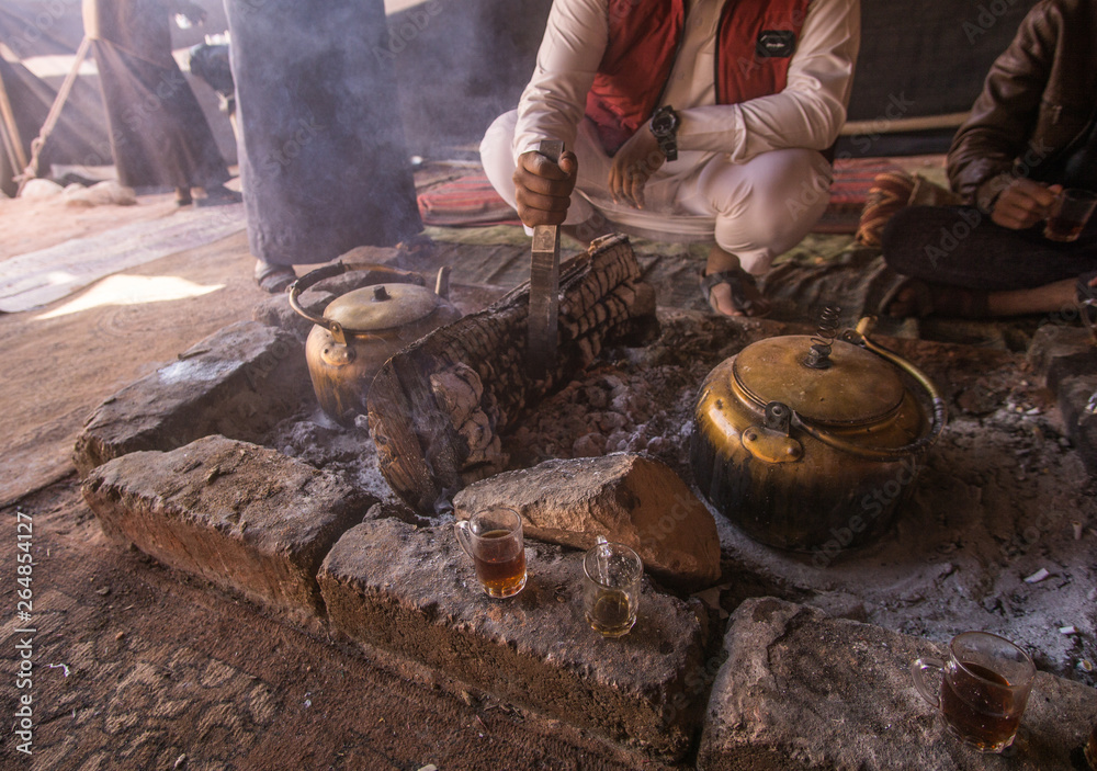 Tea glasses , teapot and people making tea during a break in a ...