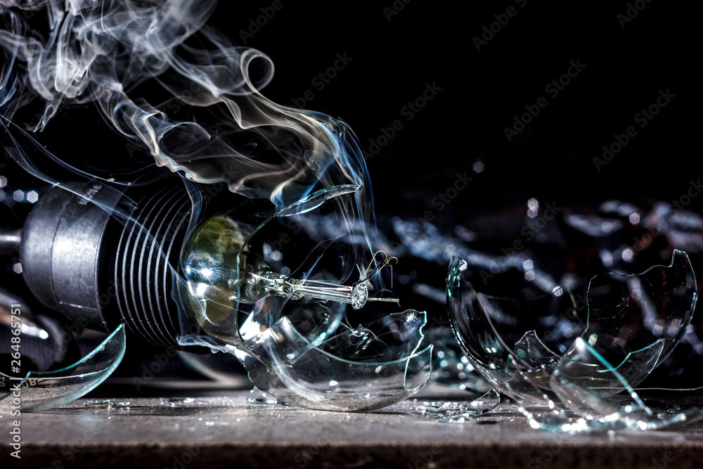 Amazing explosion of burning light bulb with splinters of broken glass ...