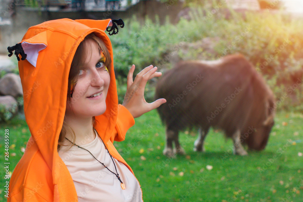 Woman at the zoo next to ox. Girl on the background of grazing Buffalo ...