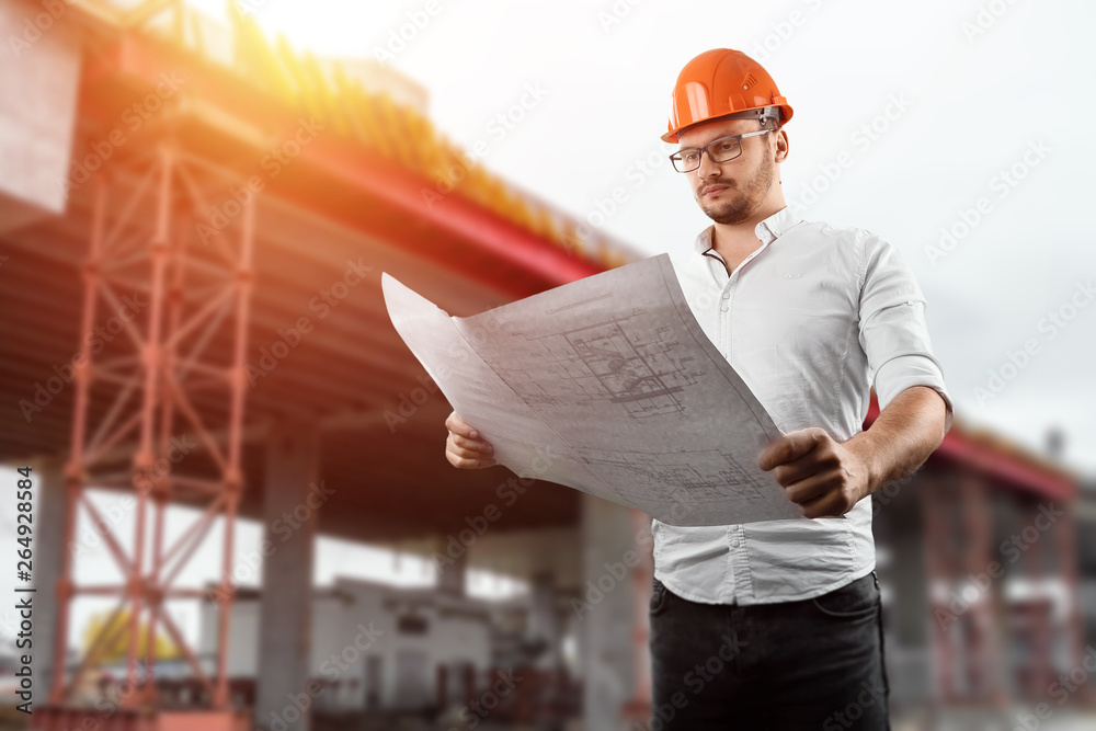 The builder, the architect holds in his hand architectural drawings on ...