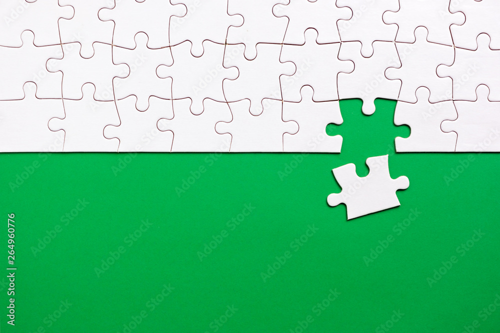 Green background made from white jigsaw puzzle pieces and place for ...