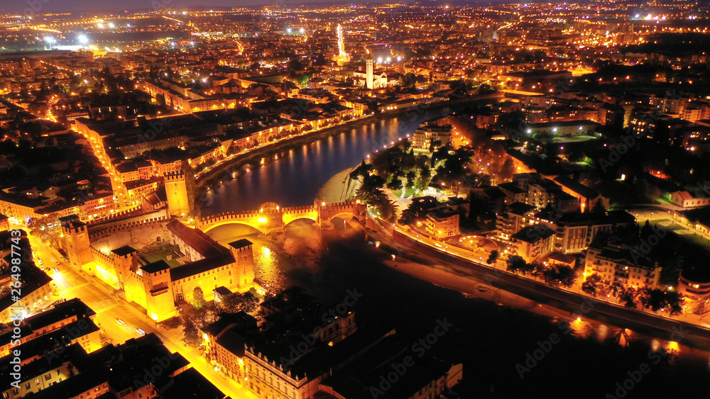 Aerial drone night shot from iconic illuminated fortified medieval castle and bridge of ...