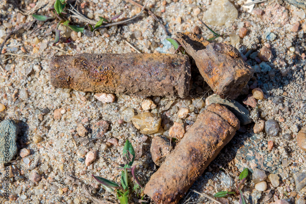Old rusty submachine gun shells in the sand on the territory of the ...
