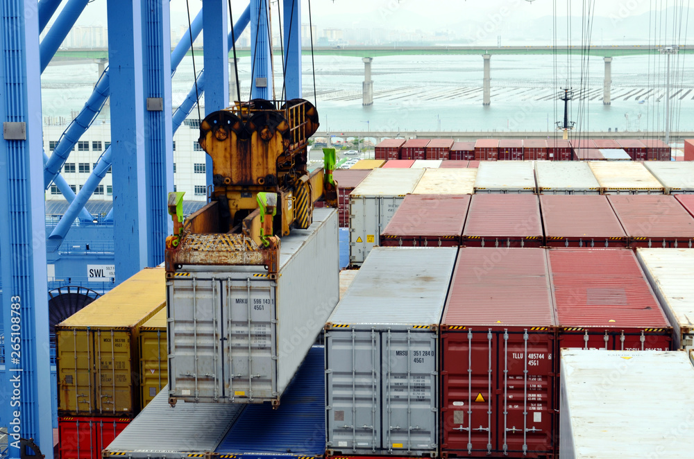 Gantry crane loading container on the cargo ship. Stock Photo | Adobe Stock