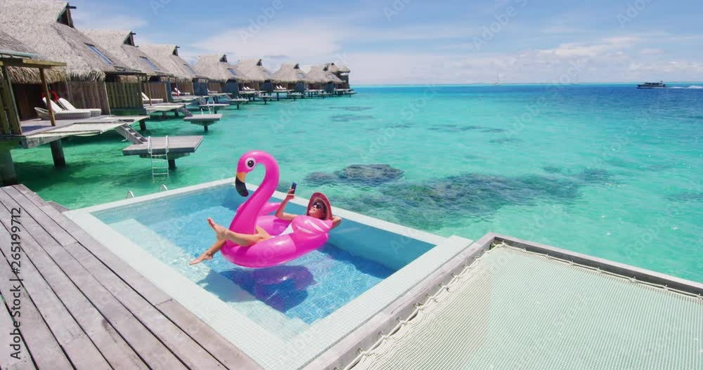 Vacation woman on inflatable Flamingo float mattress using mobile cell ...